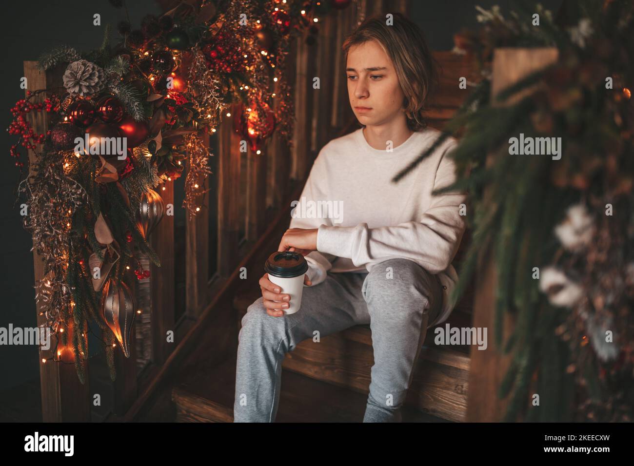 Young teen boy with long hair thoughtful look sad eyes negative mood ...