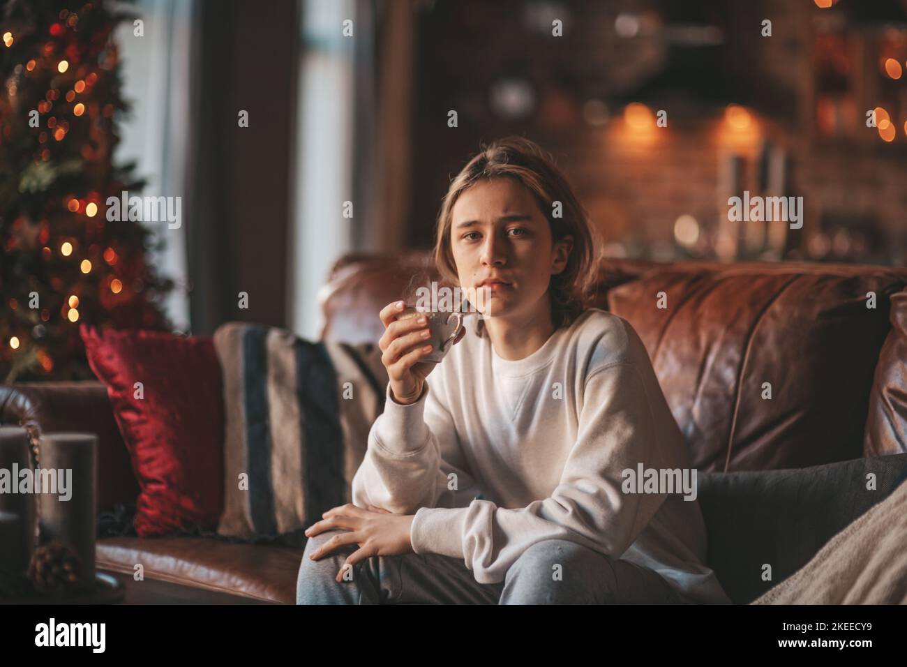 Young teen boy with long hair thoughtful look sad eyes negative mood ...