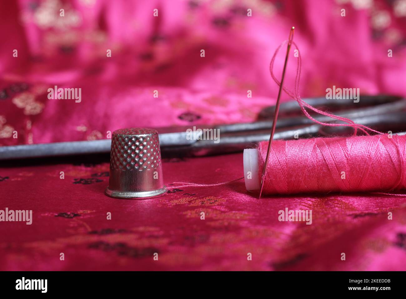 Spool of Pink Thread and Thimble on Vintage Pink Satin Stock Photo - Alamy