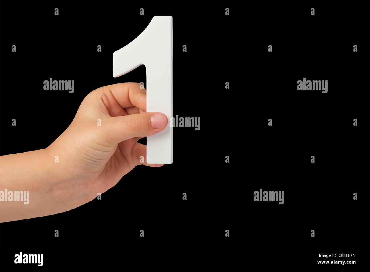 Number one in a hand isolated on a black background. Number one white ...