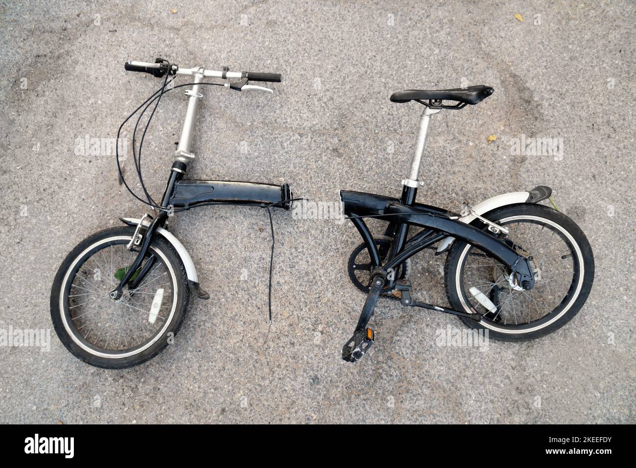 Old bicycle with a frame broken in half lying on an asphalt Stock Photo ...