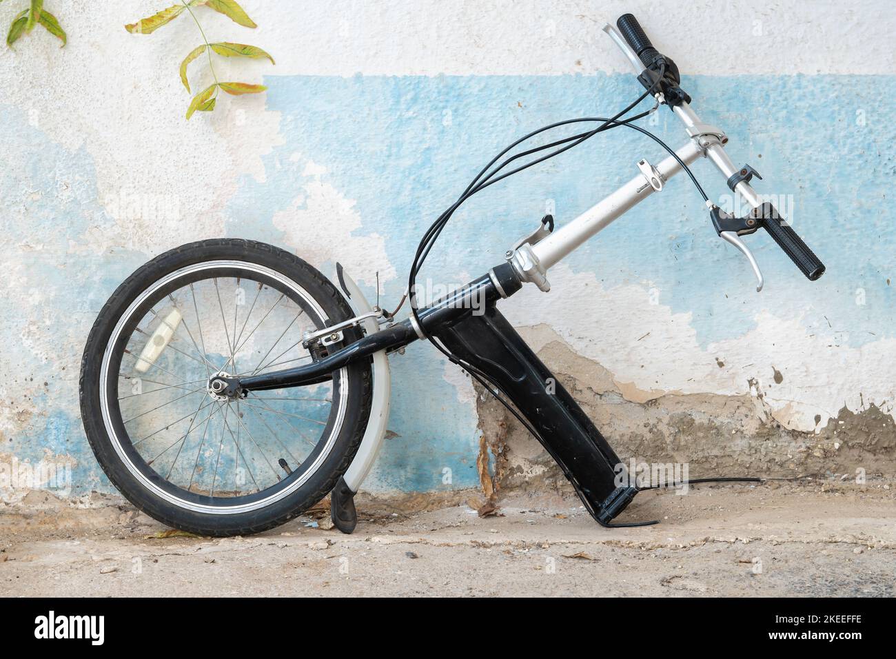 Front half of a bicycle broken into two parts against the wall Stock ...