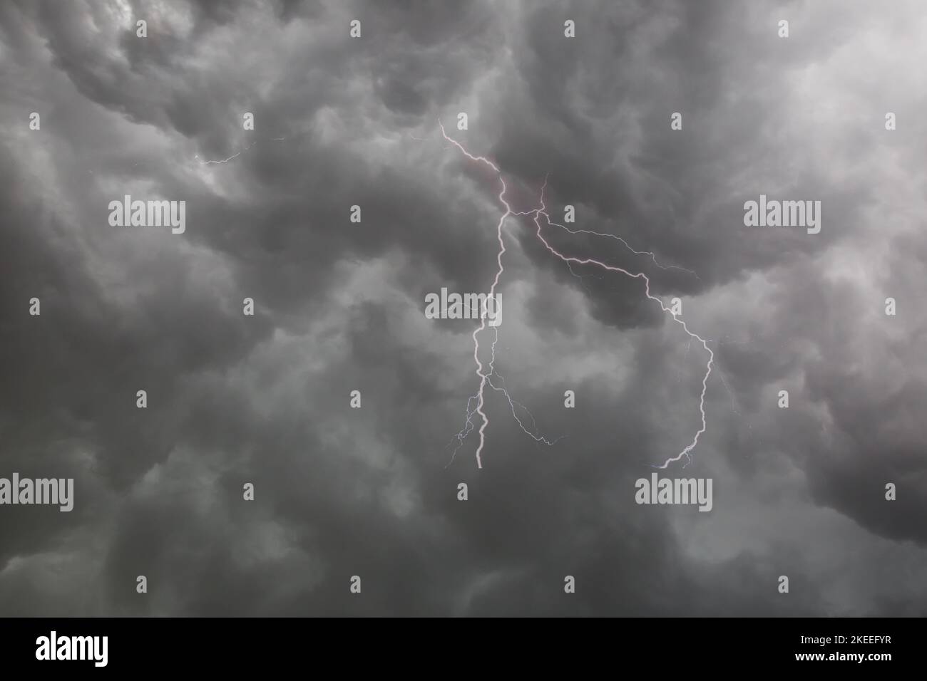 A beautiful shot of lightning striking in a stormy gray sky with ...