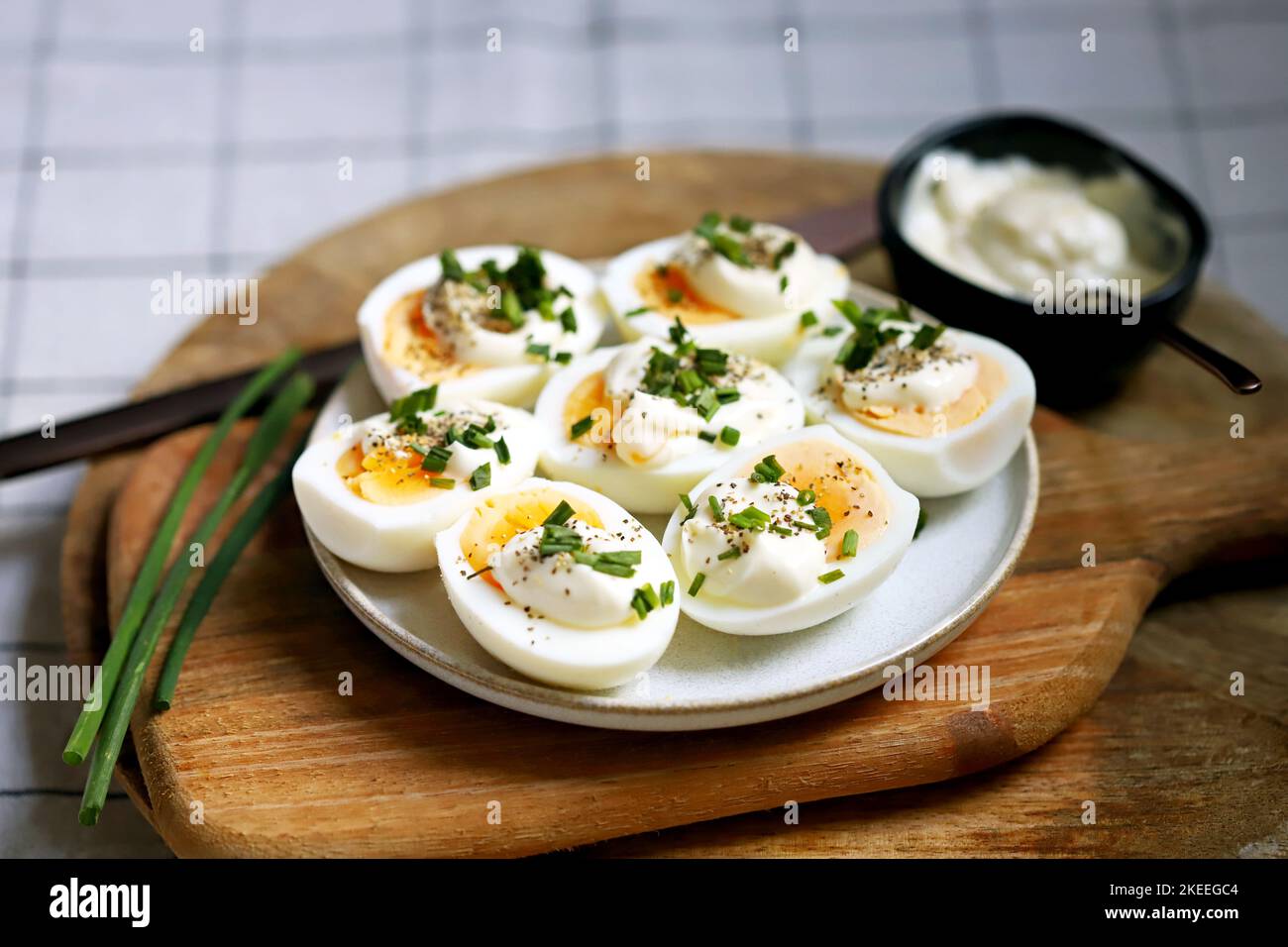 Boiled egg halves with mayonnaise and green onions Stock Photo - Alamy
