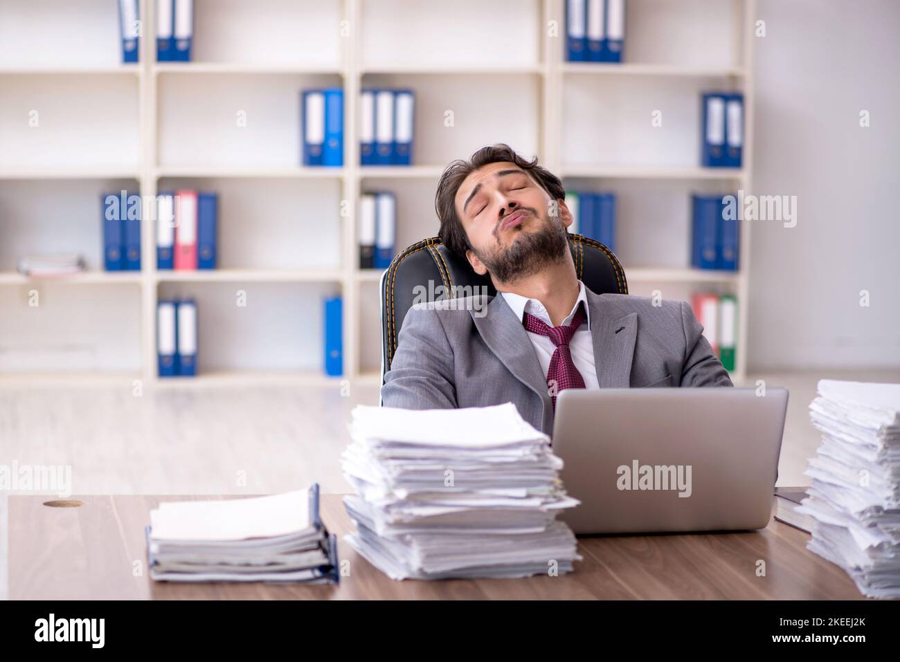 Young businessman employee and too much work in the office Stock Photo ...