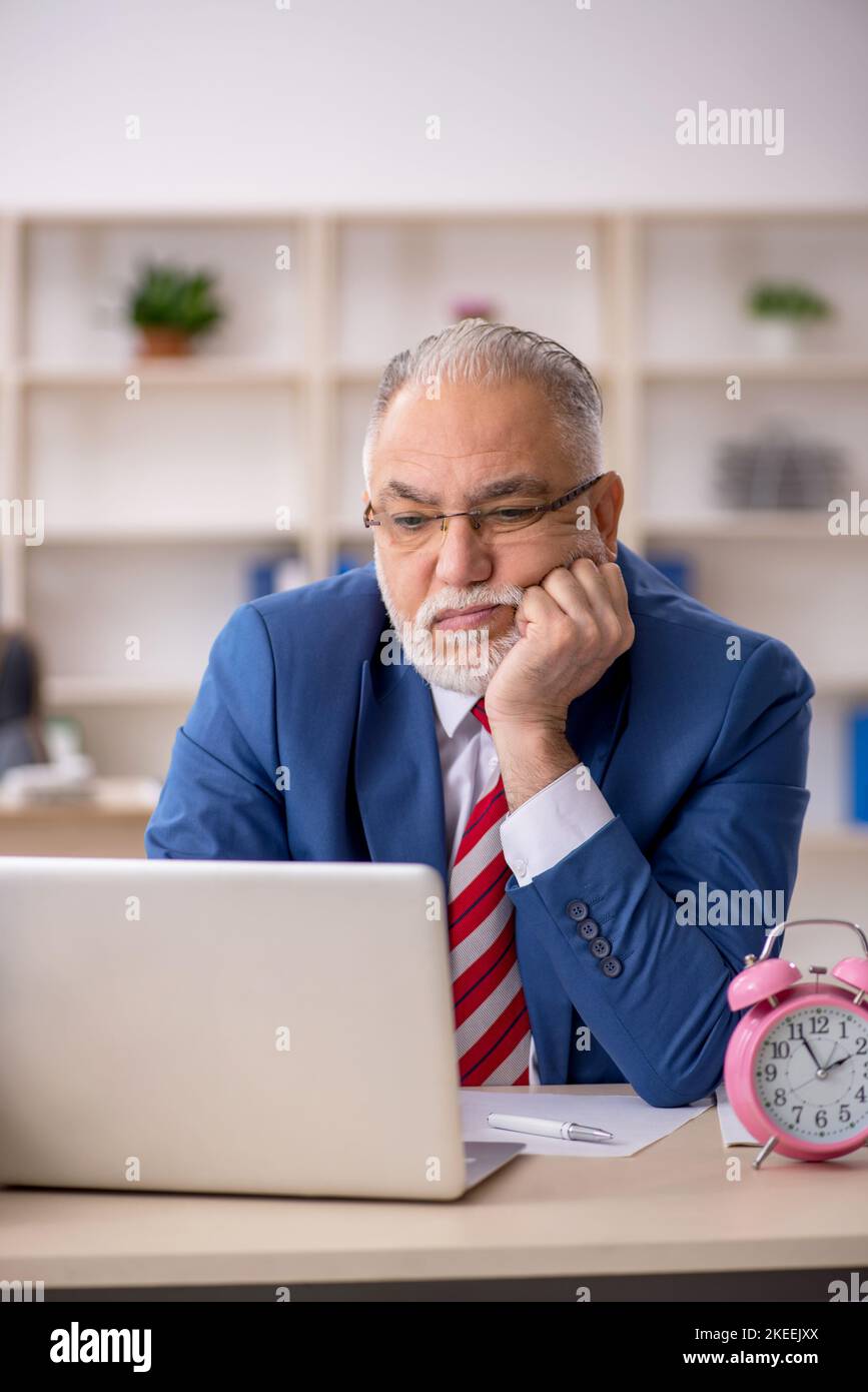 Old businessman employee in time management concept Stock Photo - Alamy