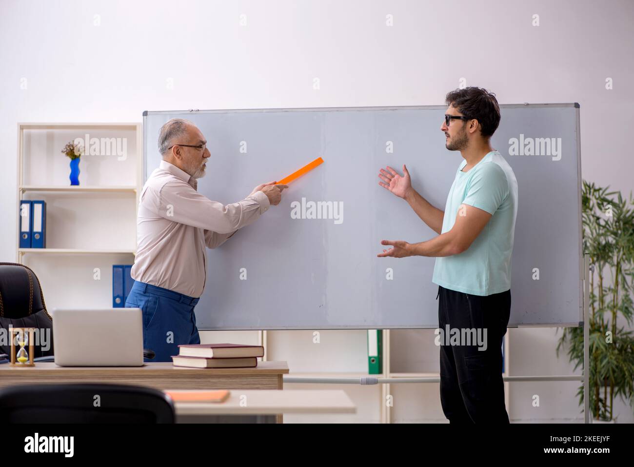 Old teacher and young student in the classroom Stock Photo - Alamy