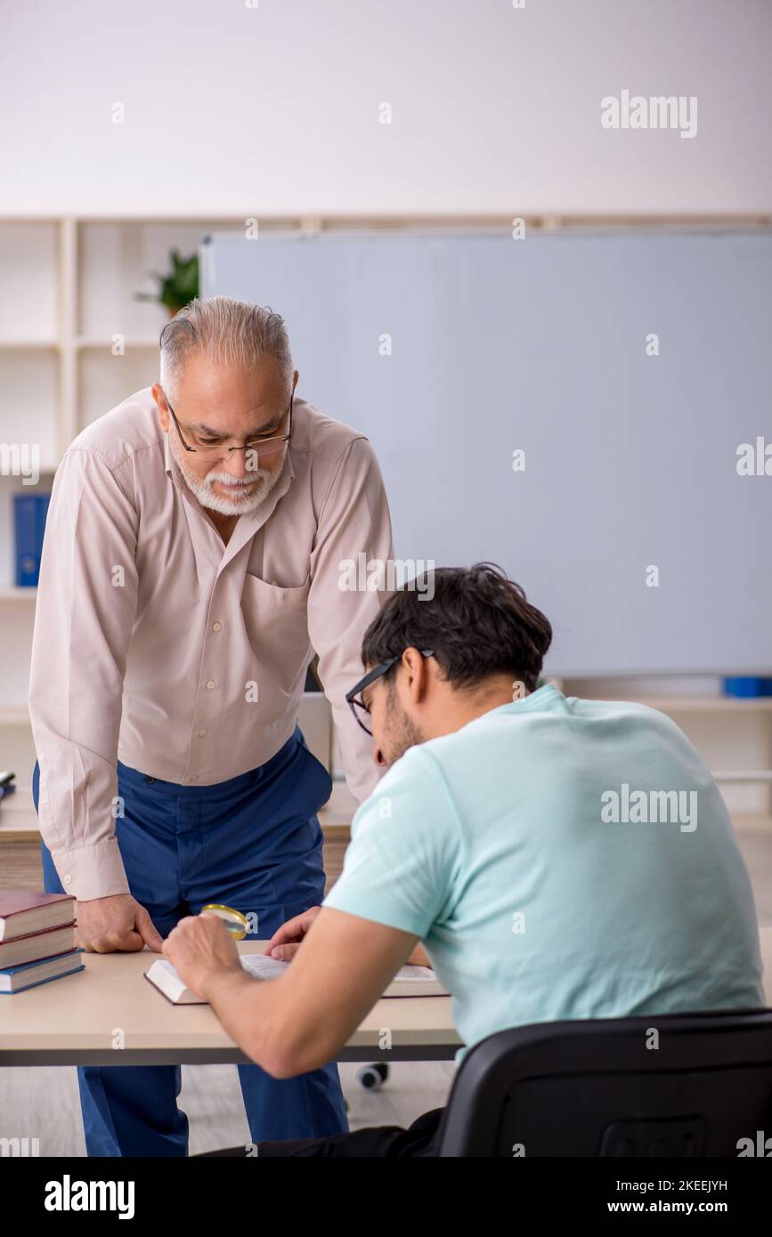 Old teacher and young student in the classroom Stock Photo - Alamy