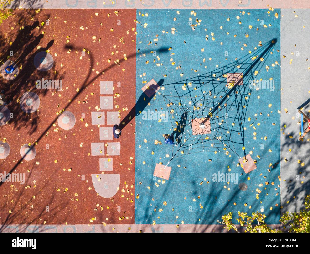 Aerial view of a colorful playground at dusk, with the shadows of the ...