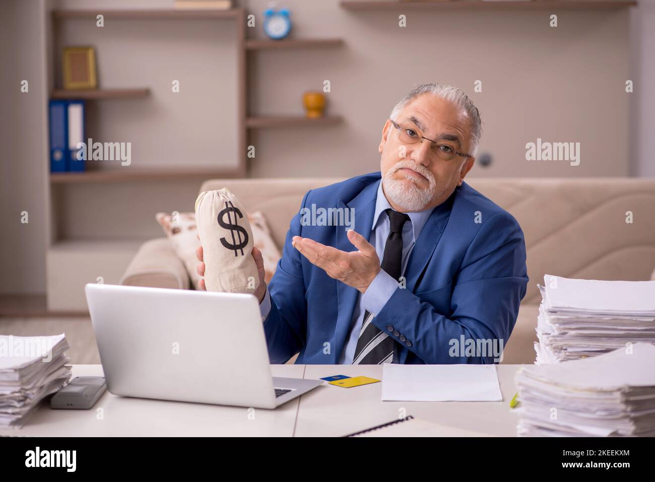 Old boss working from home in remuneration concept Stock Photo - Alamy