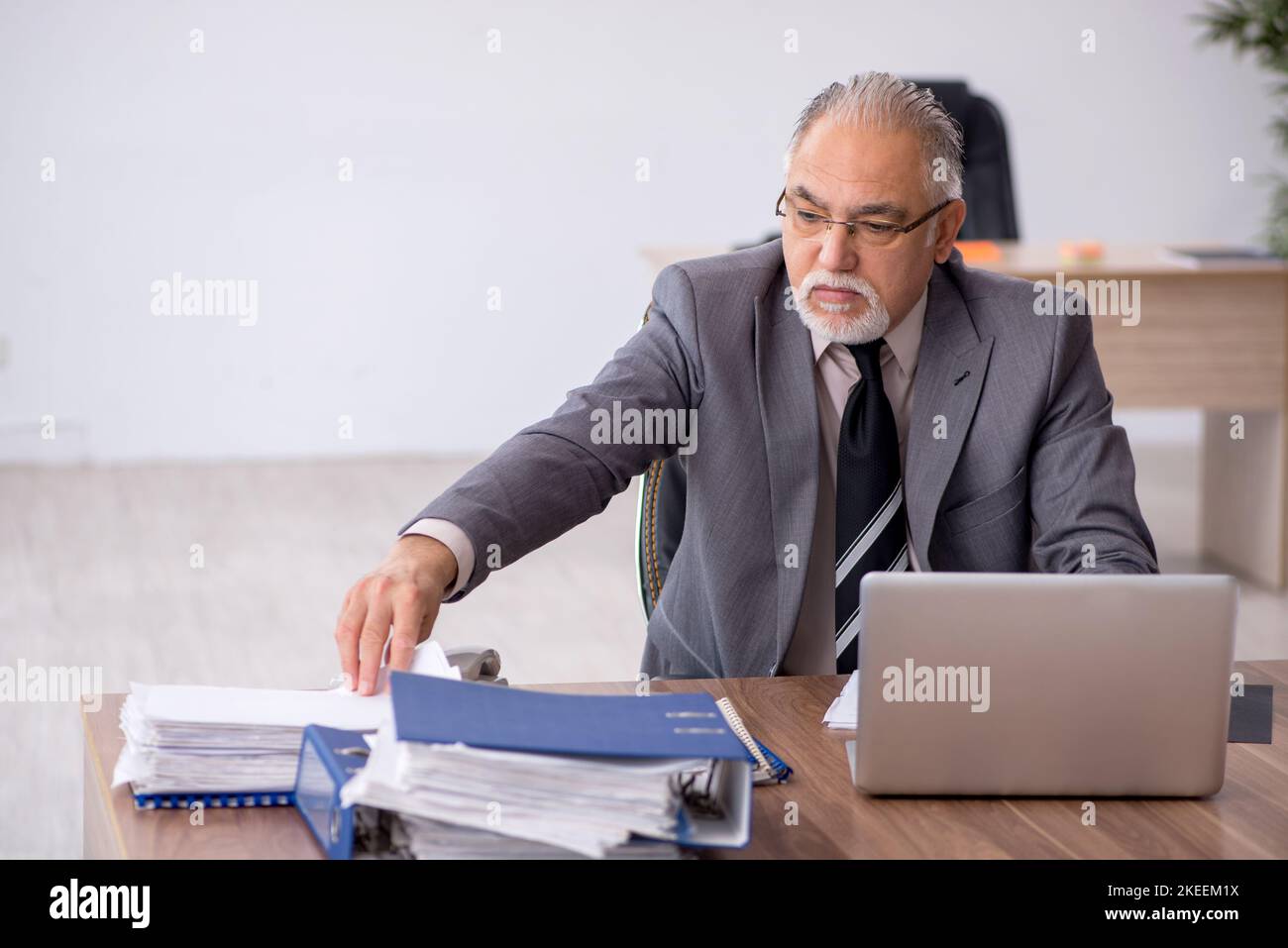 Old male boss sitting at workplace Stock Photo - Alamy