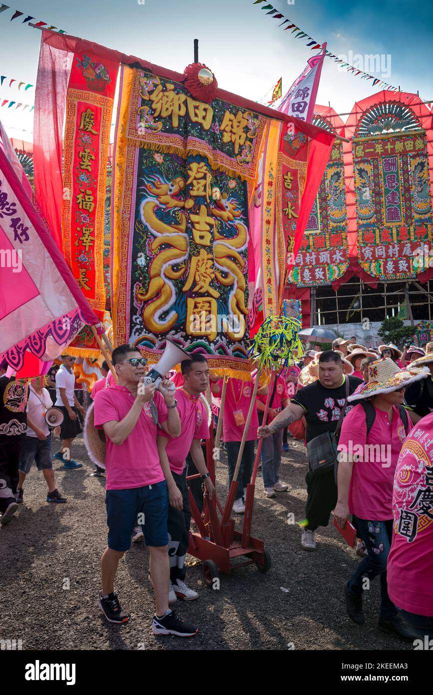 Villagers parade elaborate, colourful banners ahead of a dragon dance ...