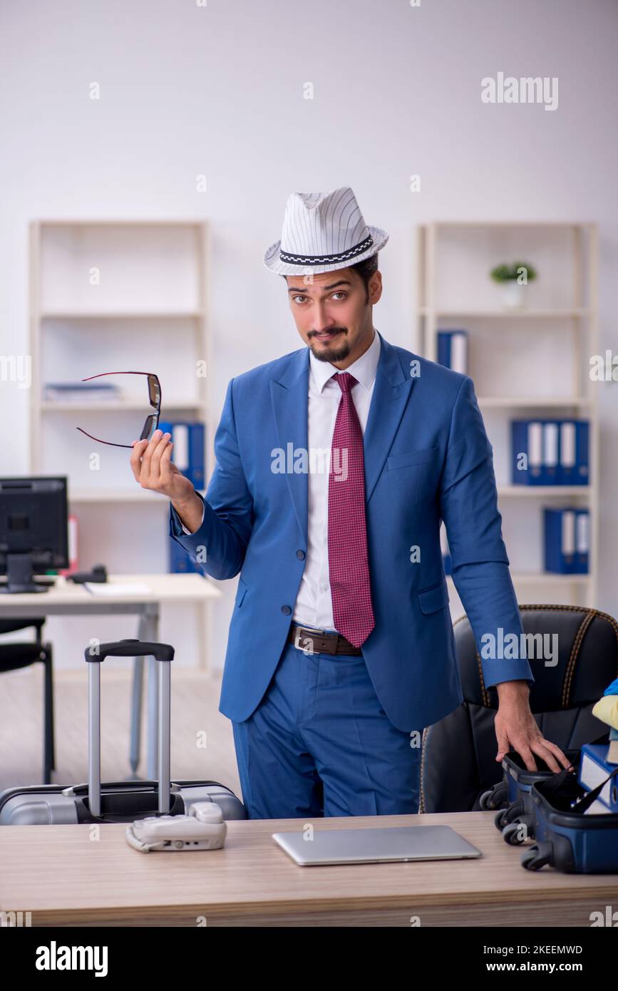 Young businessman employee preparing for trip at workplace Stock Photo ...