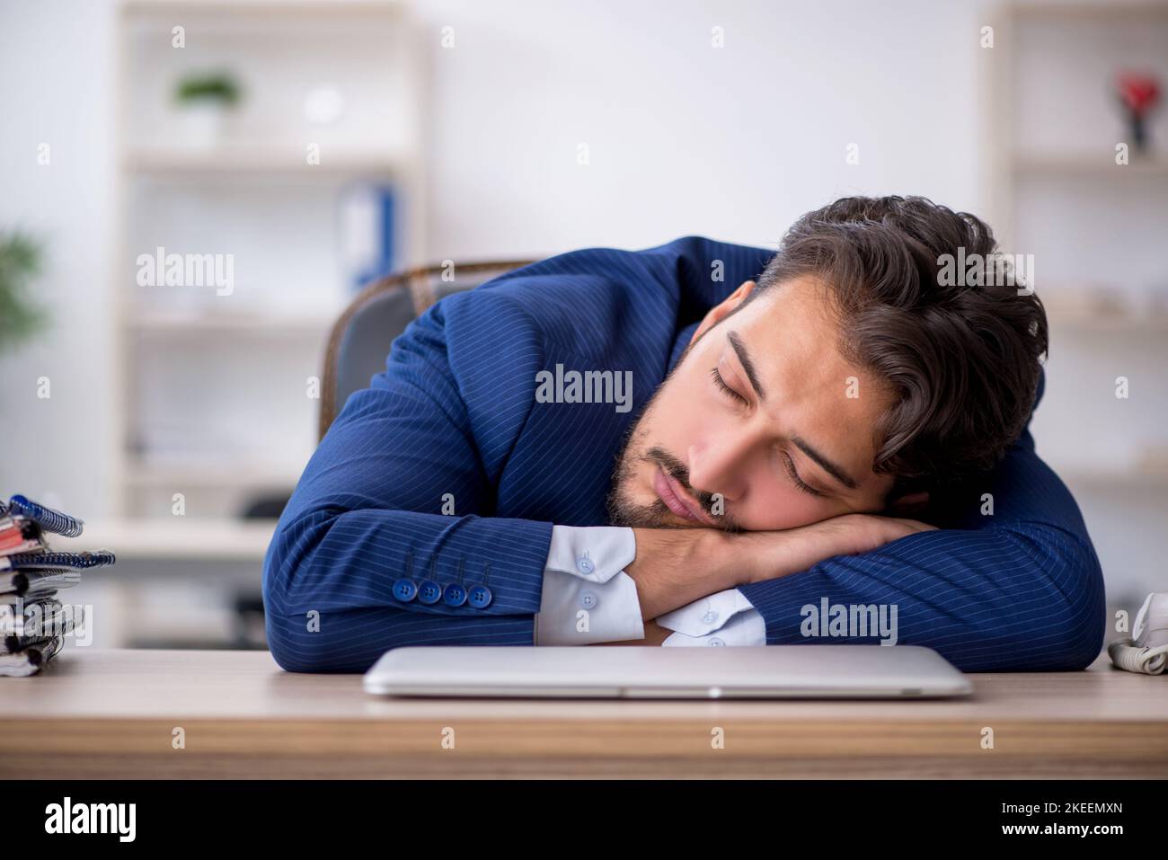 Young businessman employee extremely tired at workplace Stock Photo - Alamy