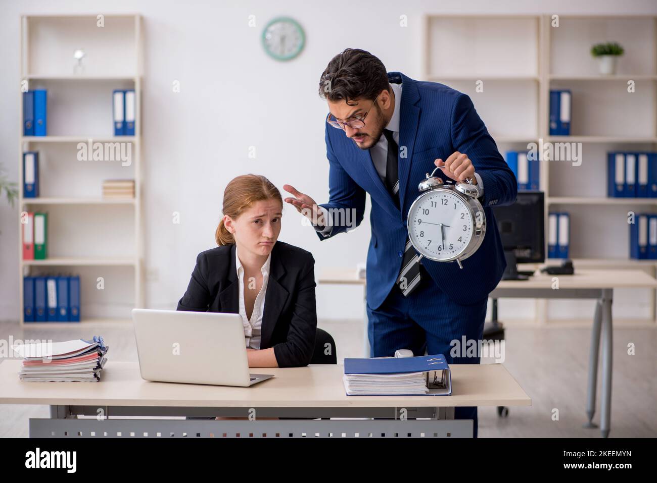 Boss and young female employee in time management concept Stock Photo ...