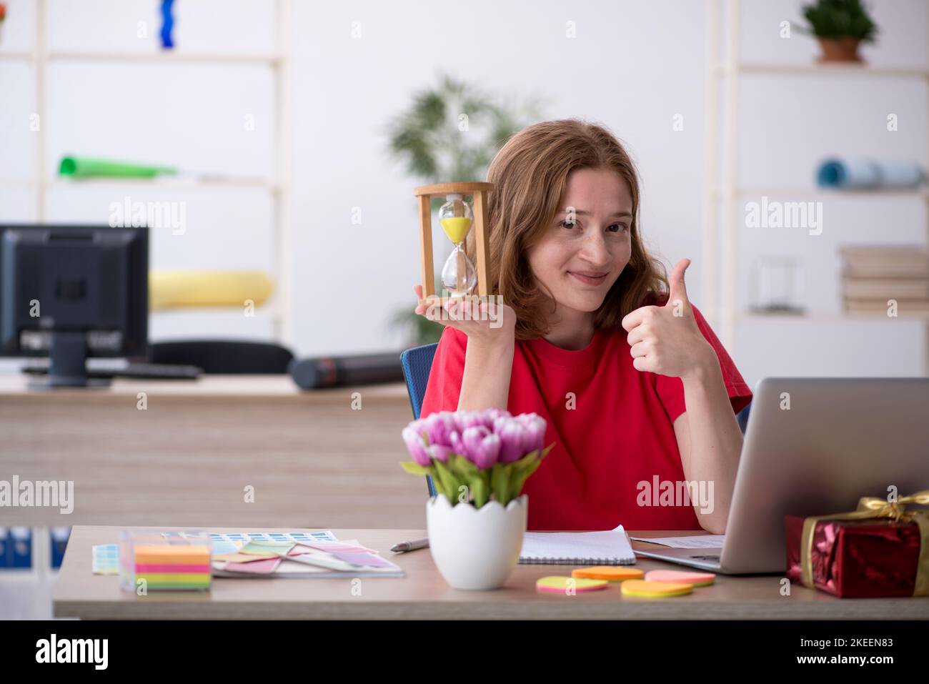 Female designer in time management concept Stock Photo - Alamy