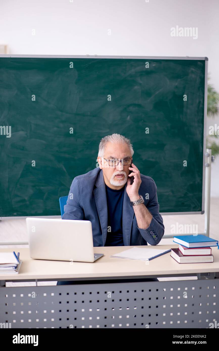 Old teacher in the classroom Stock Photo - Alamy