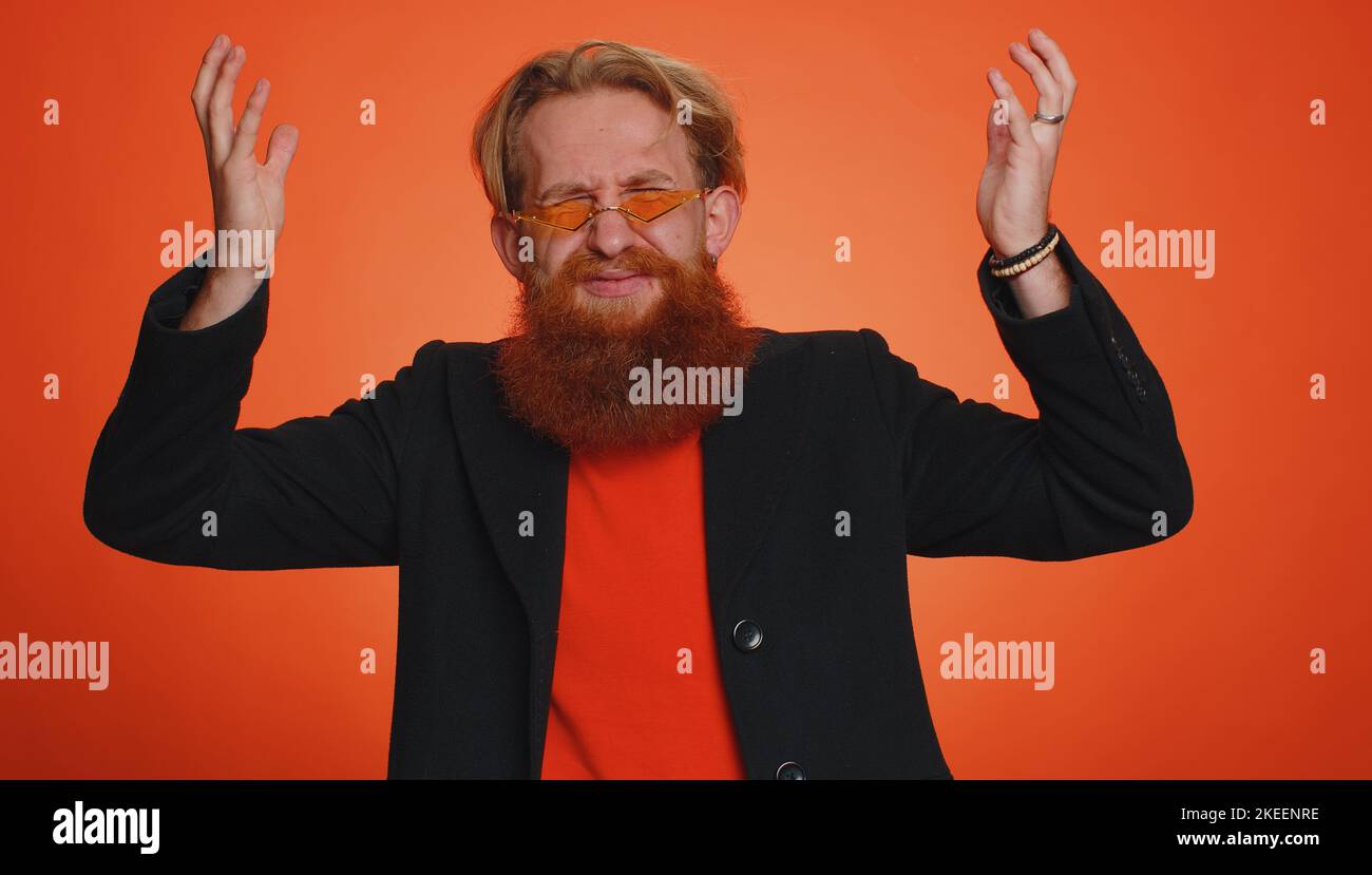 Excited amazed man 20s in jacket touching head and showing explosion ...