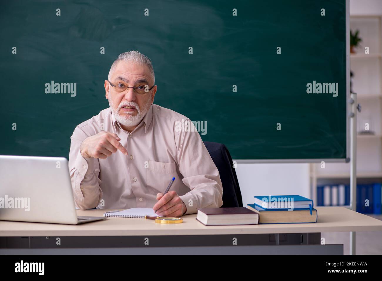 Old teacher in front of blackboard Stock Photo - Alamy