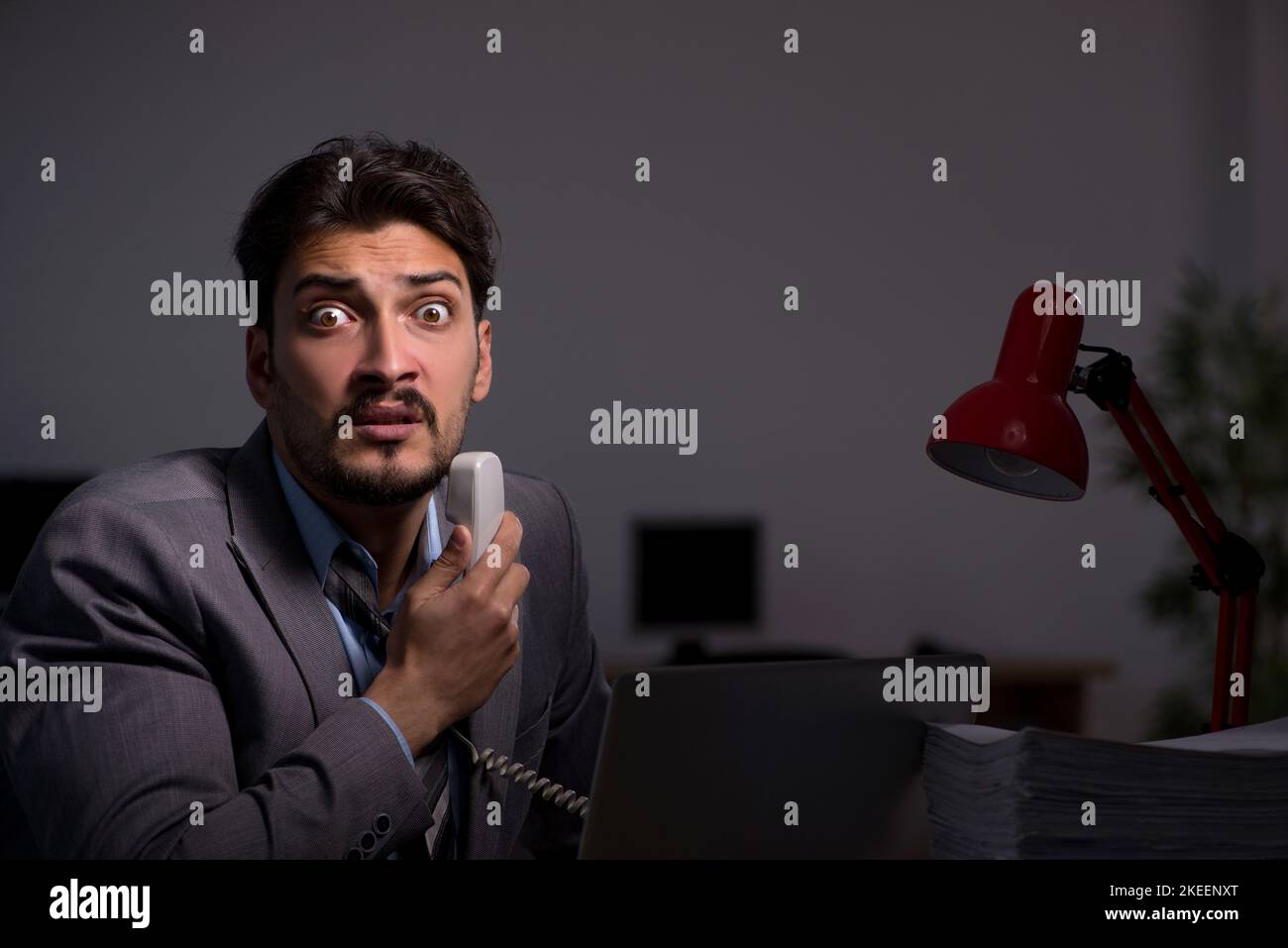 Young employee working late in the office Stock Photo - Alamy