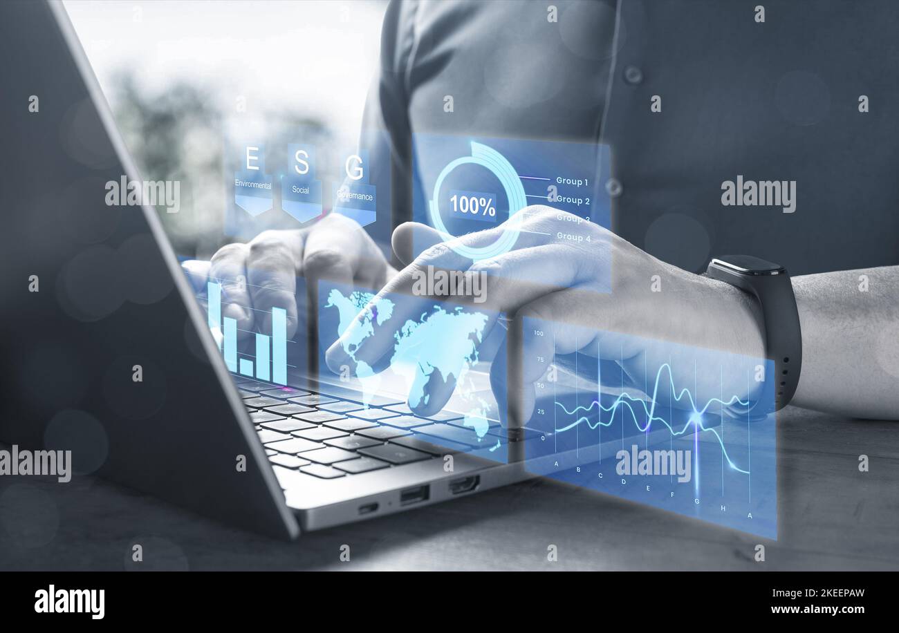 Businessman with laptop and virtual screen with graphs of financial and ...
