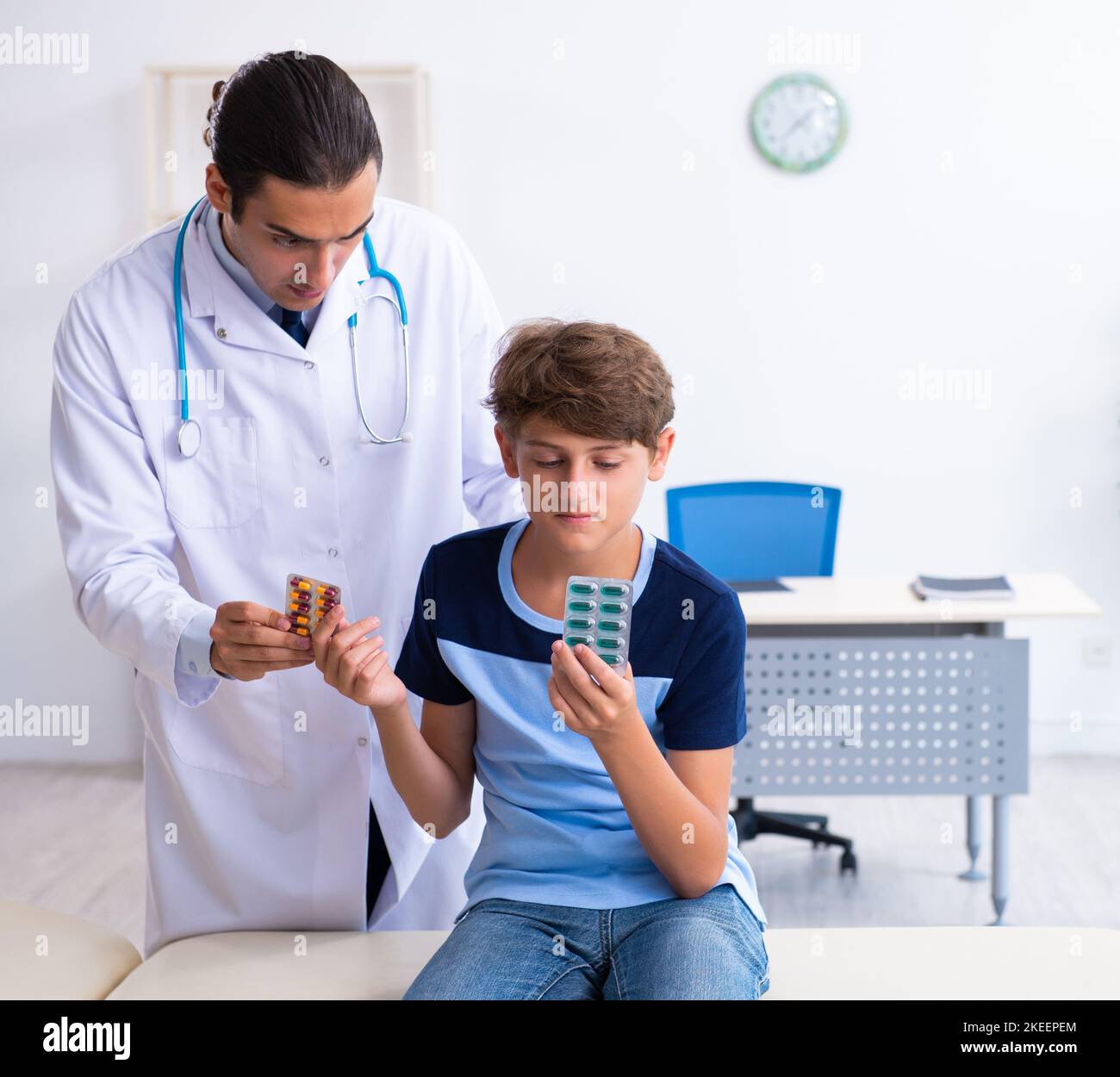 The young male doctor examining boy in the clinic Stock Photo - Alamy