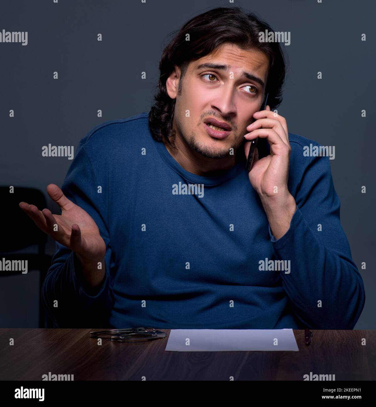 The young convict man sitting in dark room Stock Photo - Alamy