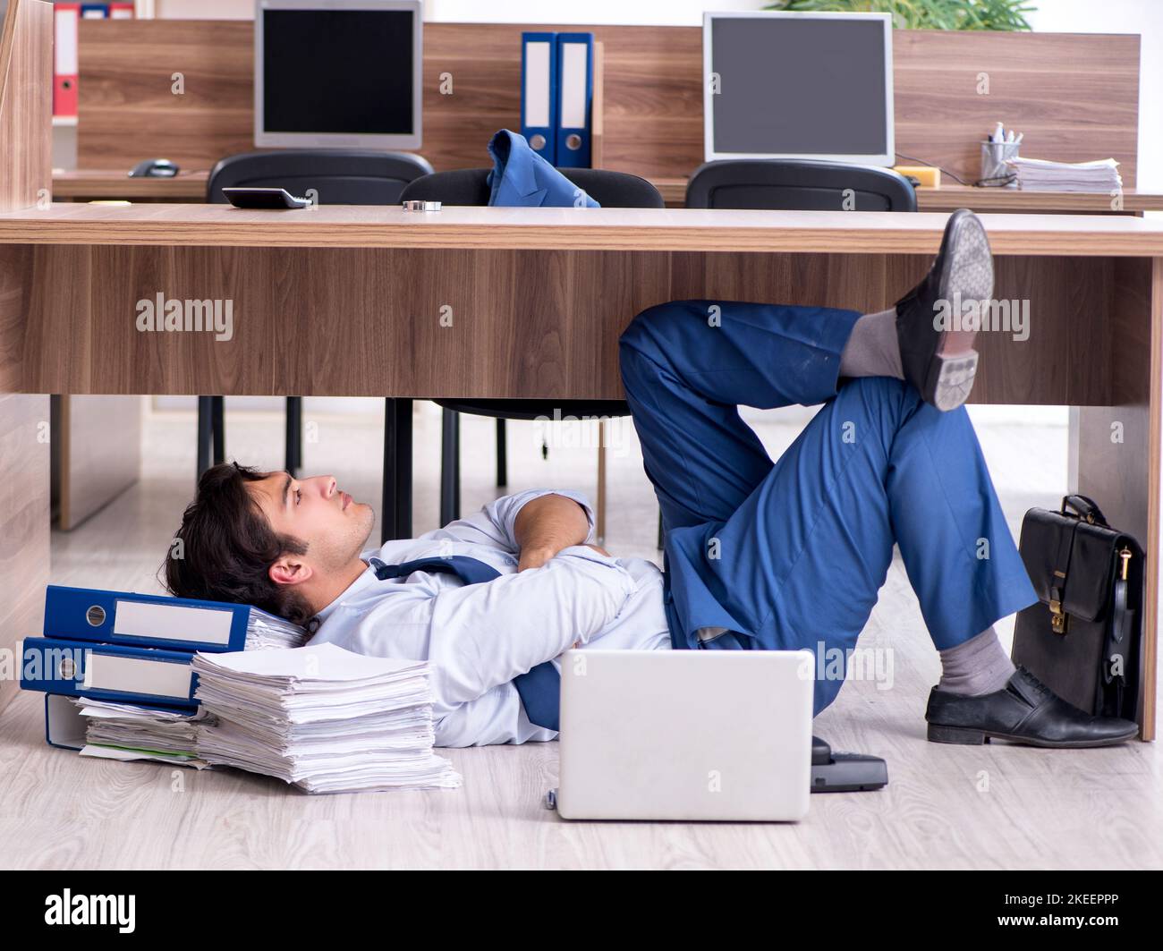 The young male employee and too many work in the office Stock Photo - Alamy