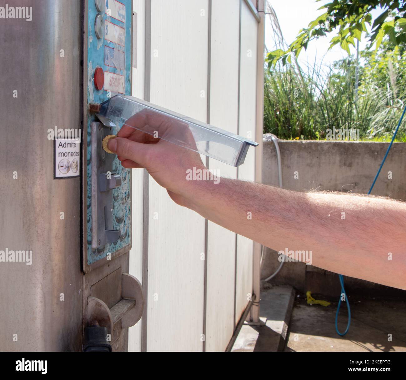 A hand inserting a coin into a car wash machine Stock Photo - Alamy