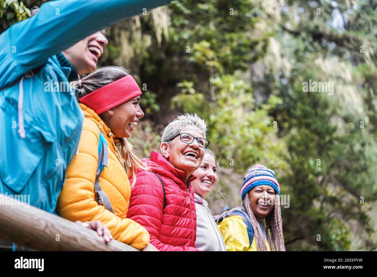 Multiracial women having fun exploring nature on trekking day in ...