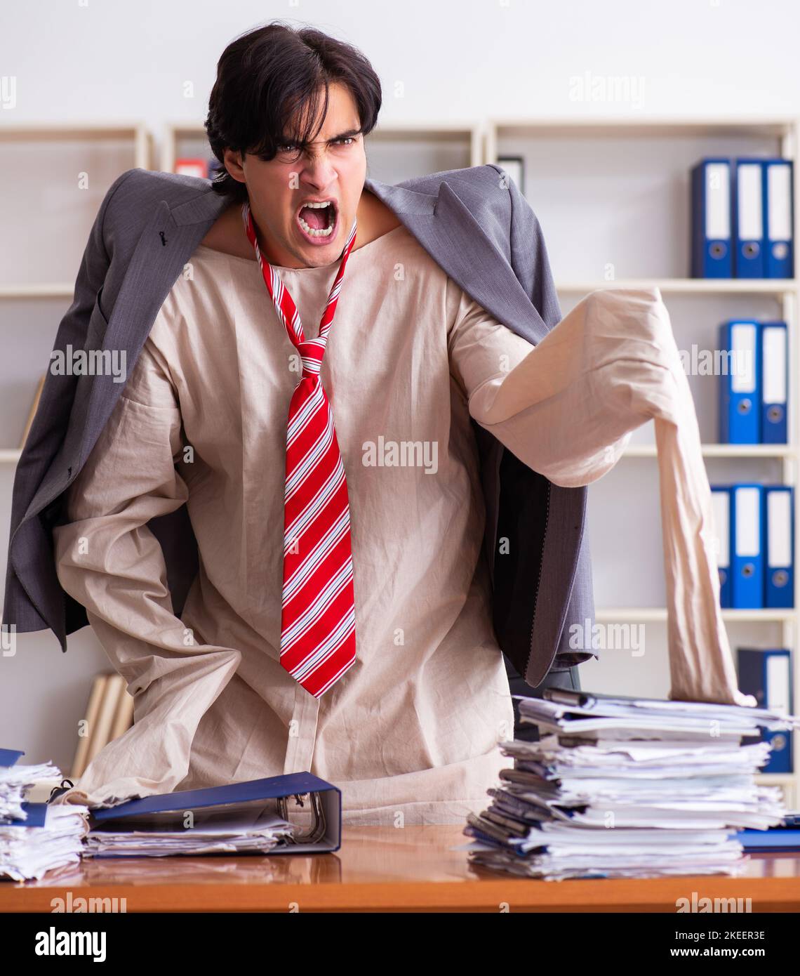 The crazy young man in straitjacket at the office Stock Photo - Alamy