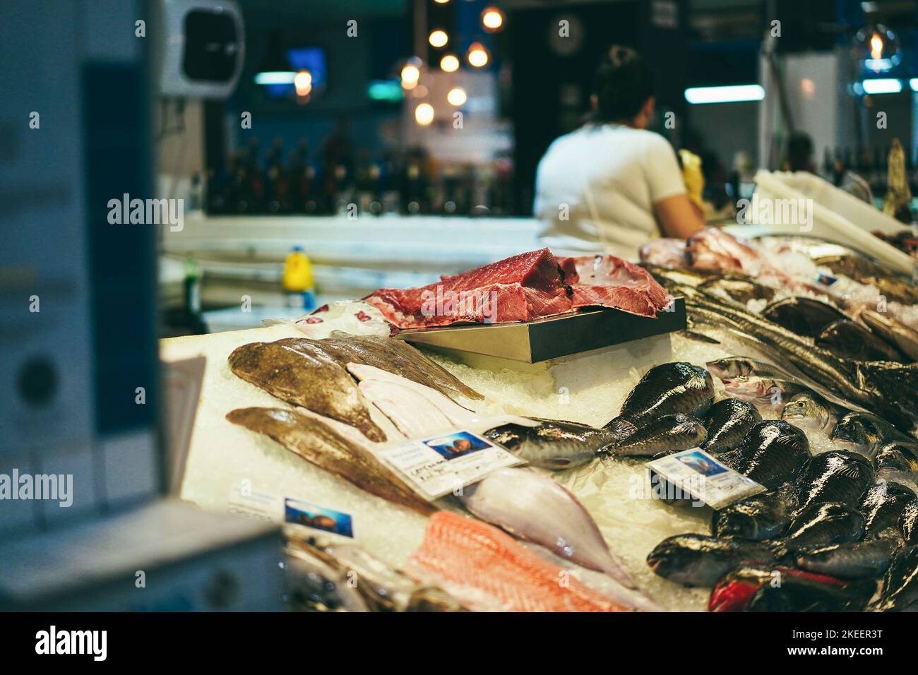 Fishmonger woman working inside seafood market - Focus on tuna fish ...