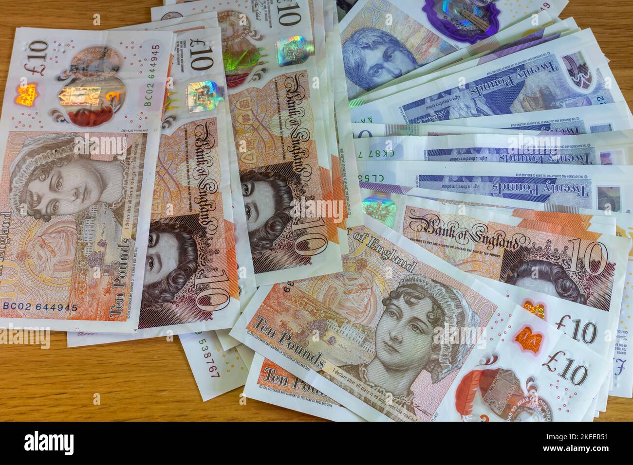 A pile of British £20 and £10 pound notes laid out on a table Stock ...