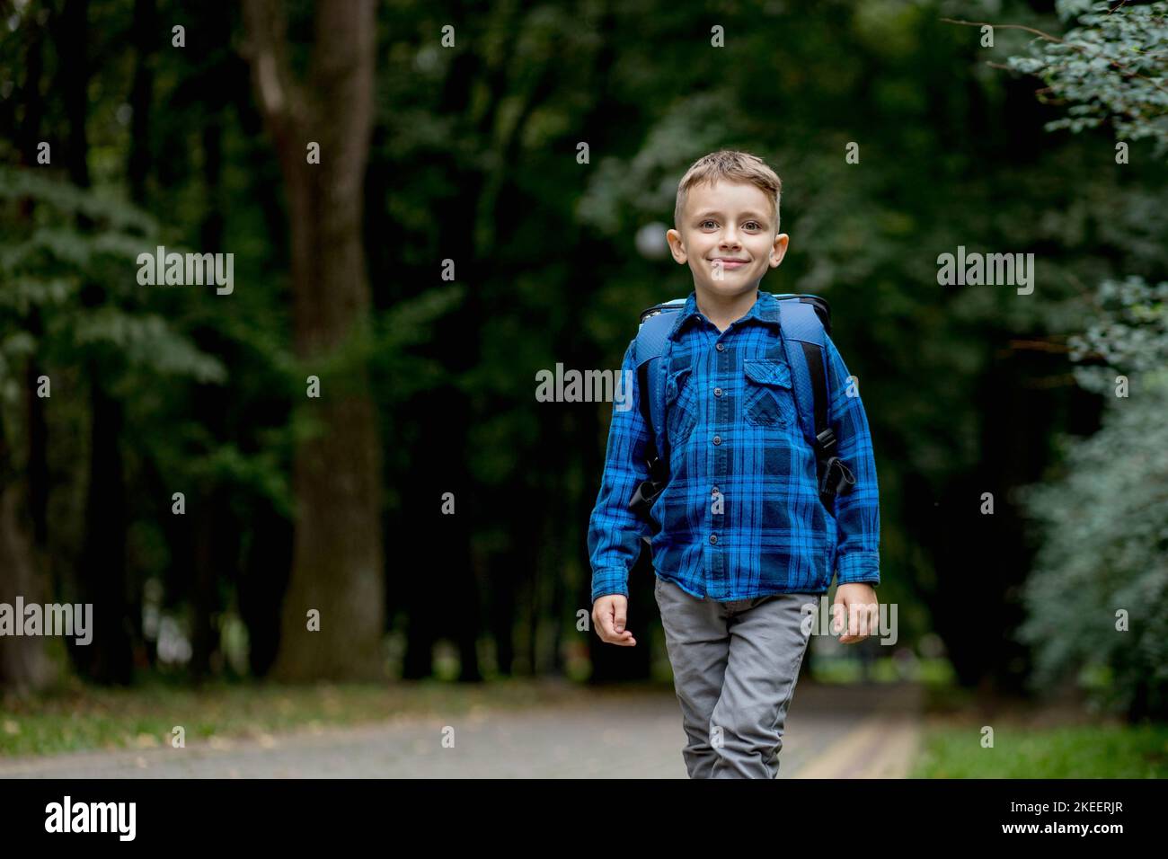 Portrait of a first grader with a backpack. The boy goes to school ...