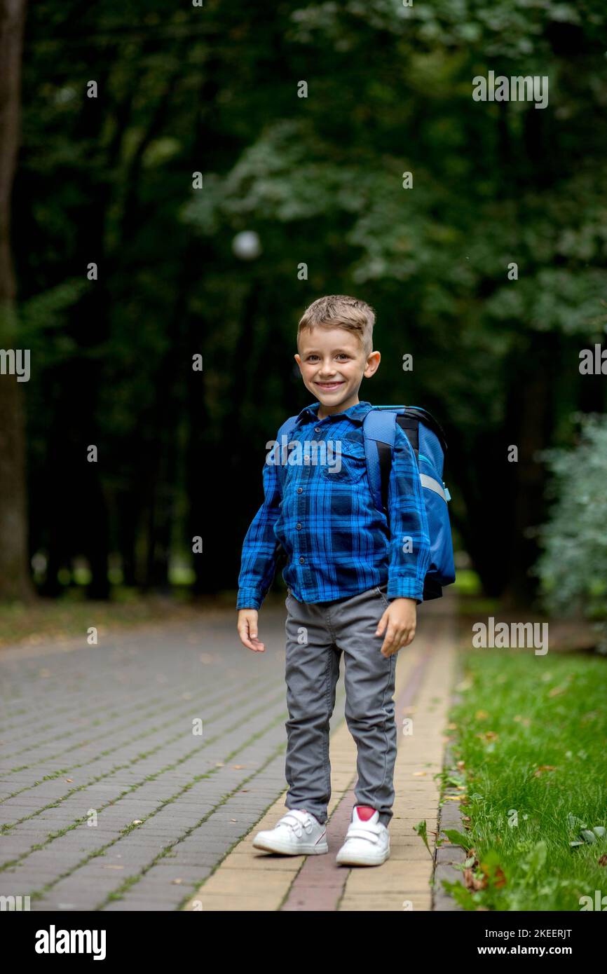 Portrait of a first grader with a backpack. The boy goes to school ...