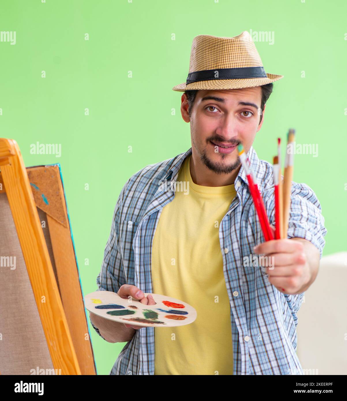 The young male artist working on new painting in his studio Stock Photo ...