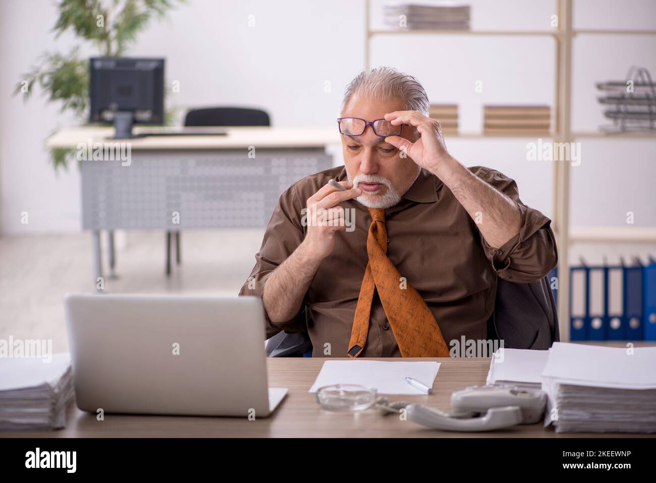 Old businessman employee smoking cigarette at workplace Stock Photo - Alamy