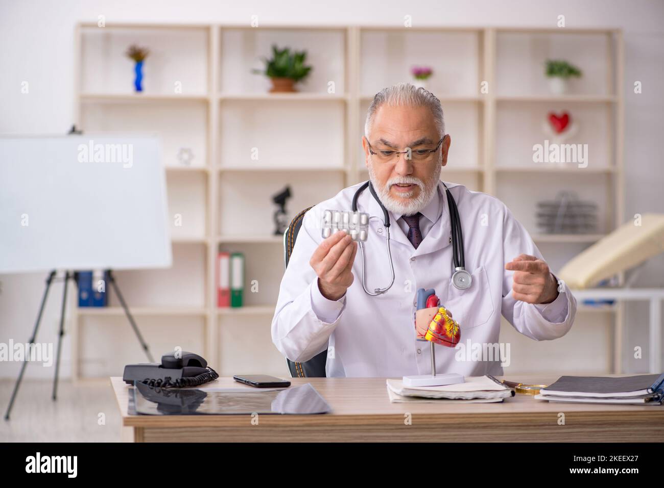 Old doctor cardiologist working in the clinic Stock Photo - Alamy