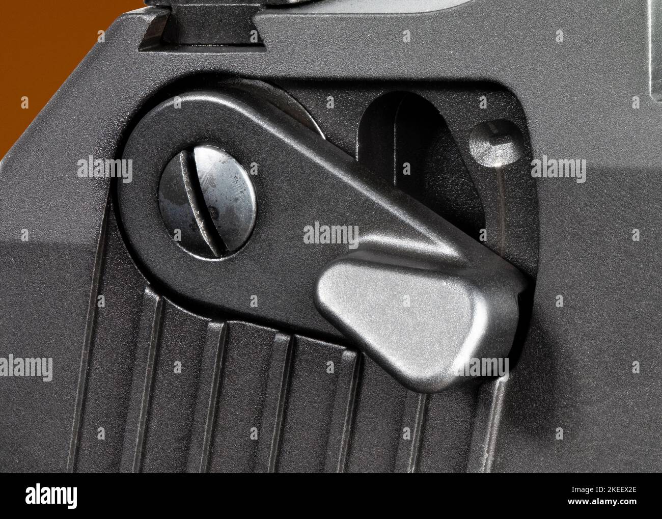 Safety lever on a pistol with brown background Stock Photo - Alamy