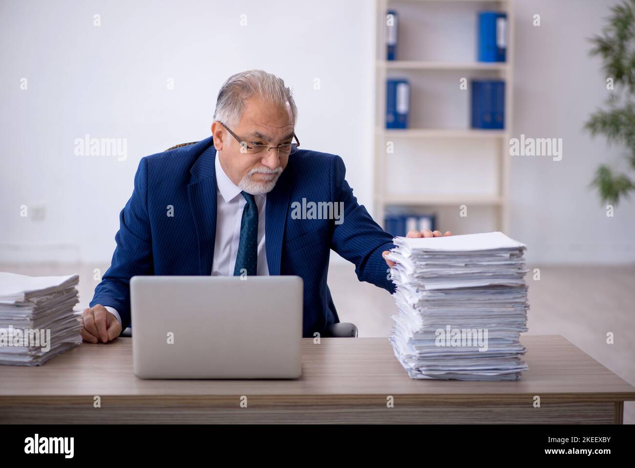 Old businessman employee and too much work at workplace Stock Photo - Alamy