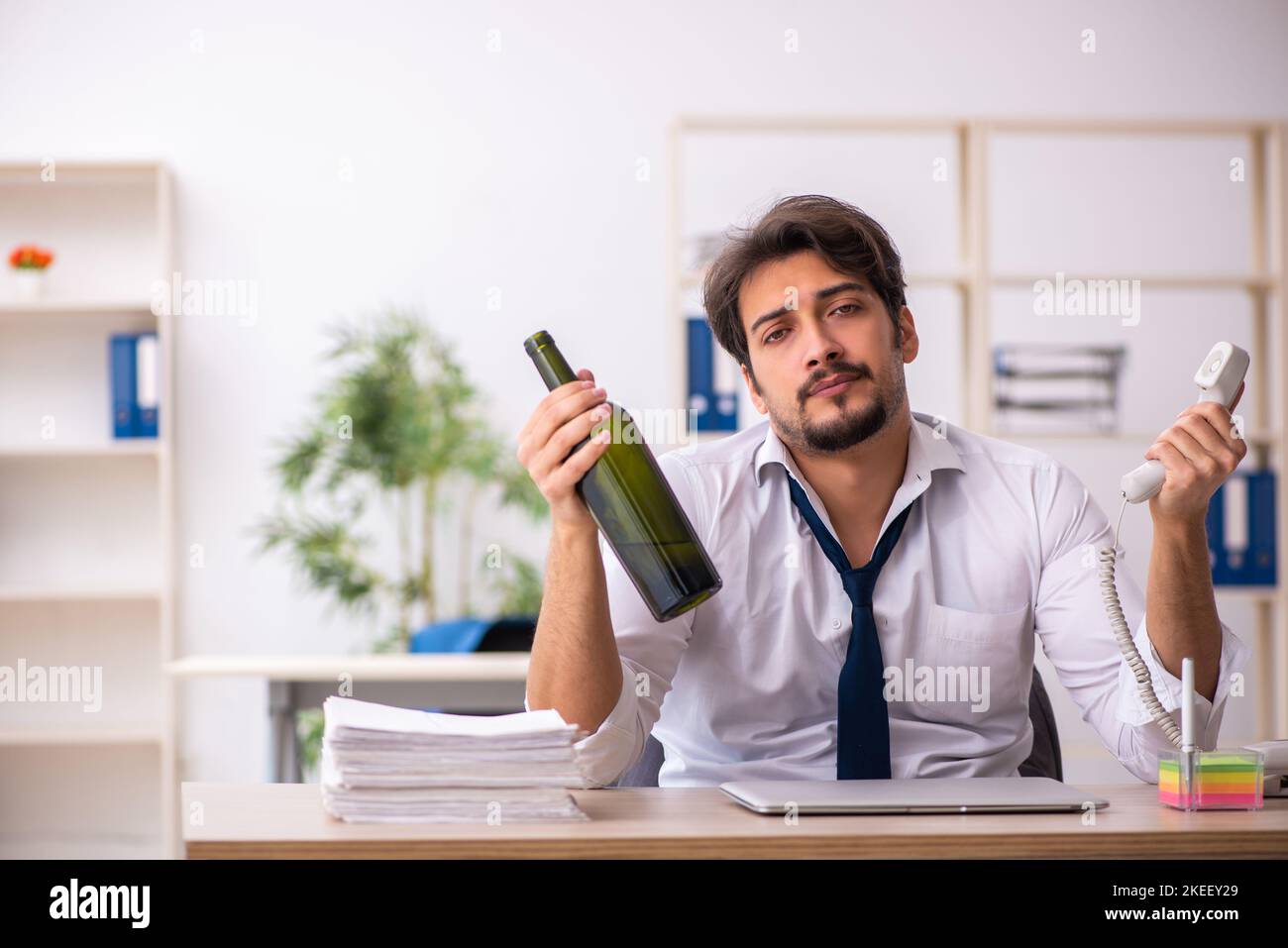 Male alcohol addicted employee sitting in the office Stock Photo - Alamy