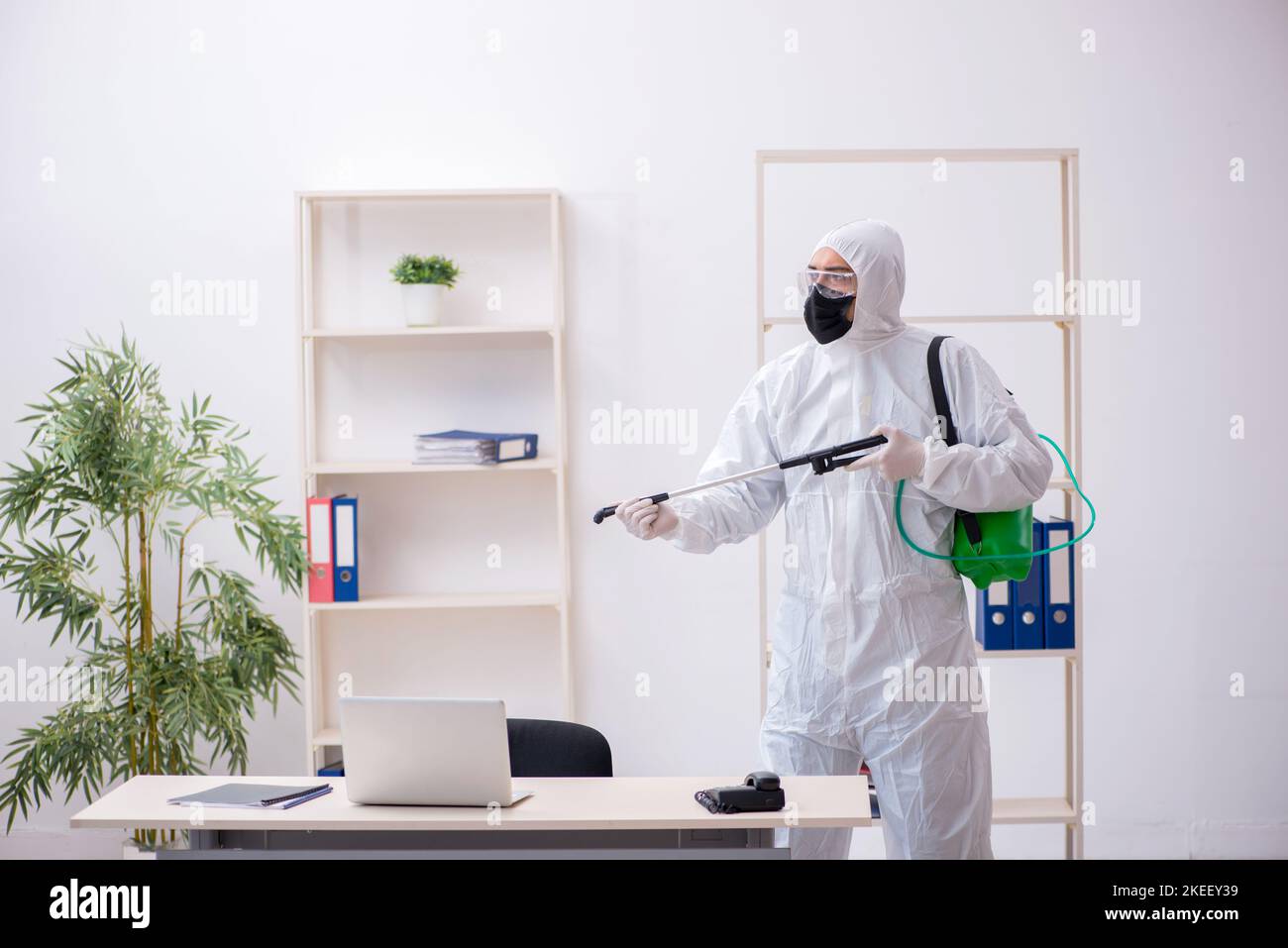 Young contractor disinfecting office during pandemic Stock Photo - Alamy