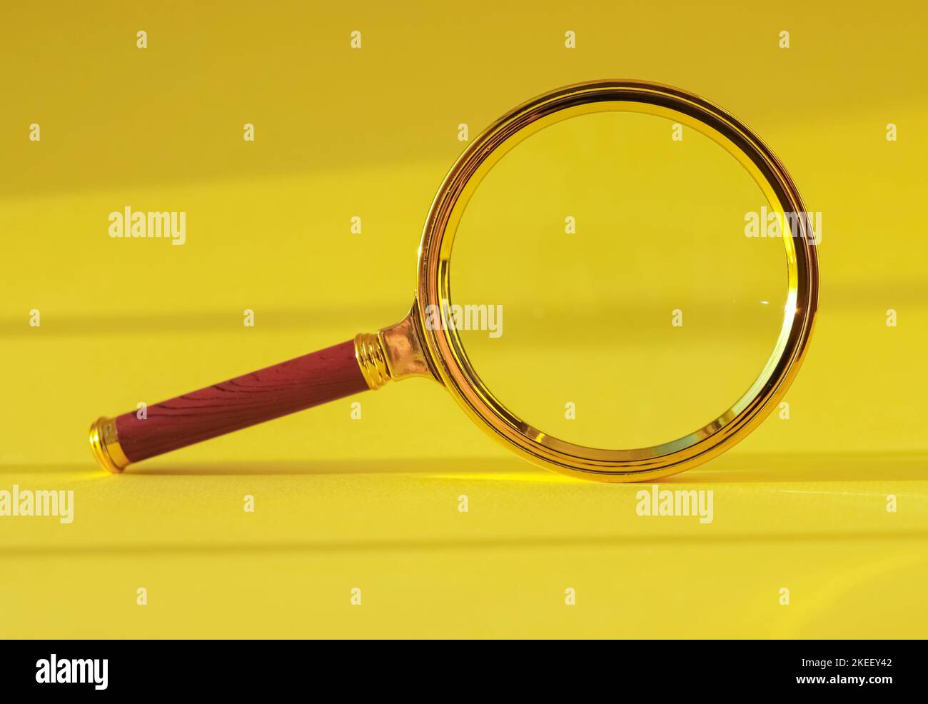 Magnifying glass on yellow background with light and shadow Stock Photo ...