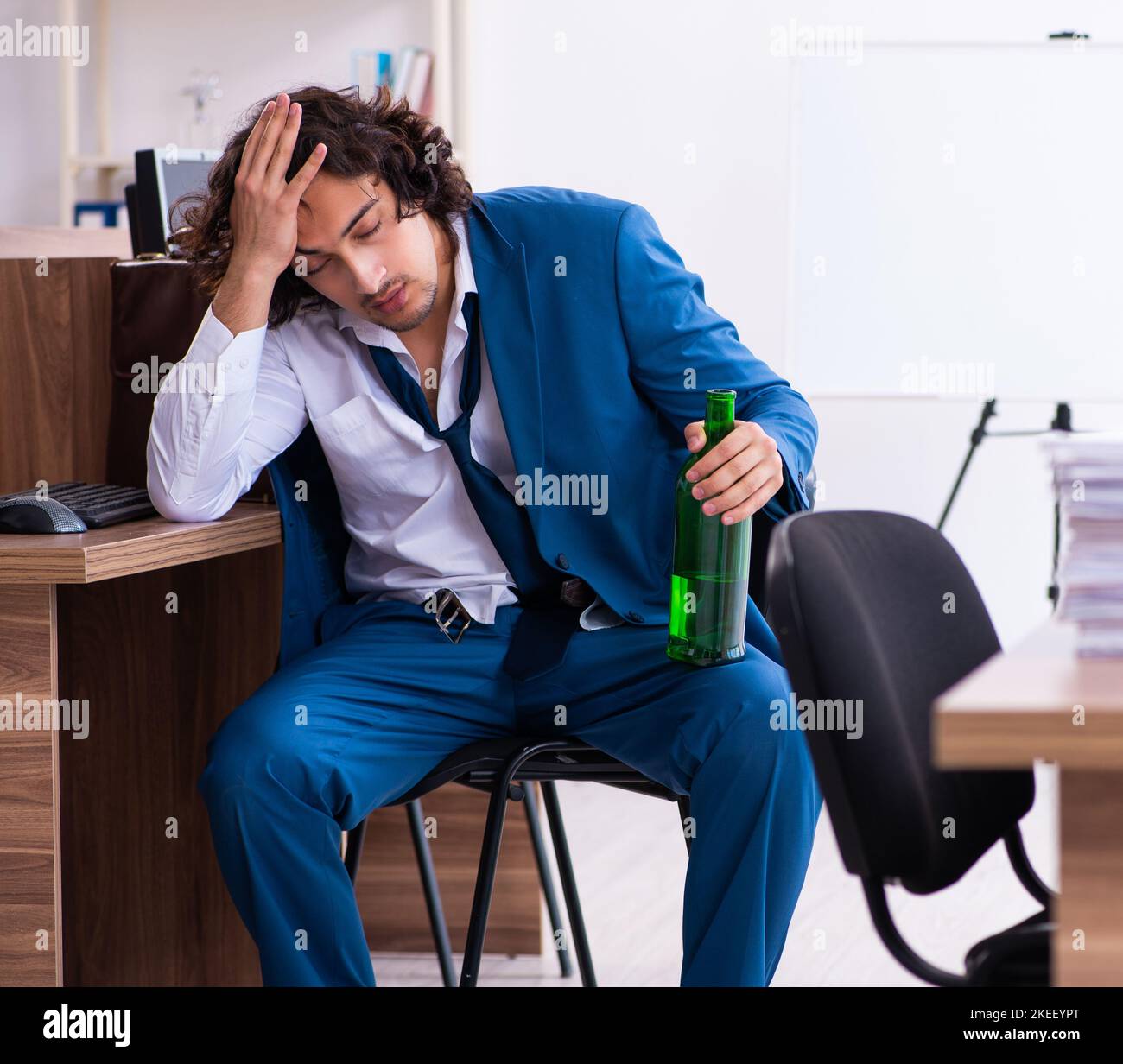 The young drunk employee in the office Stock Photo - Alamy