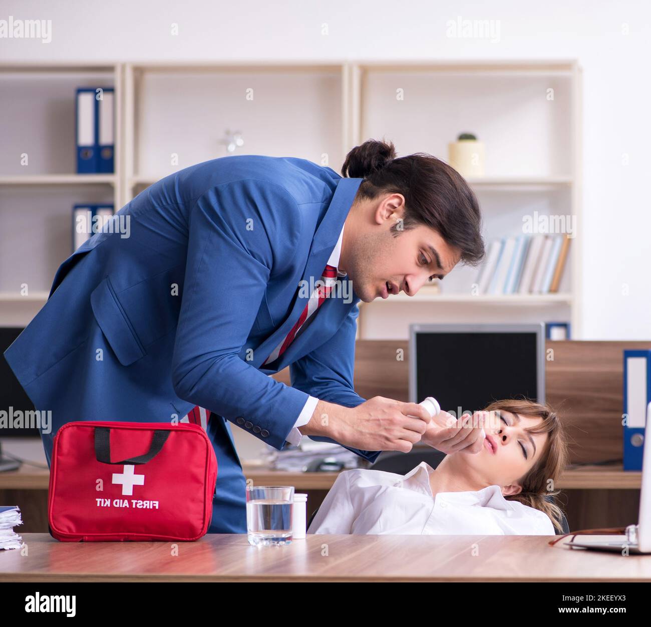 Employee receiving first aid in office Stock Photo - Alamy