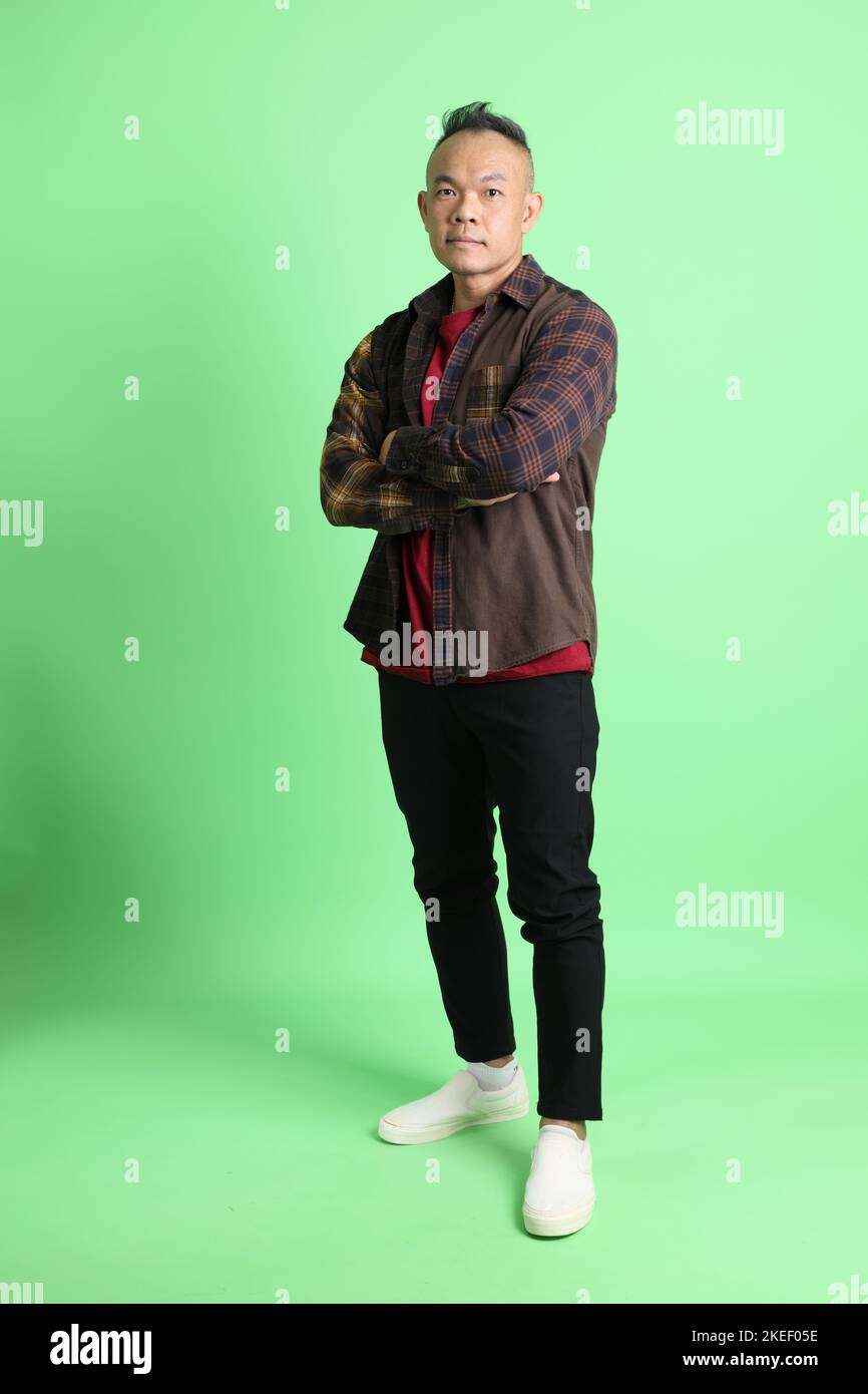 The 40s adult Asian man with plaid shirt standing on the green ...