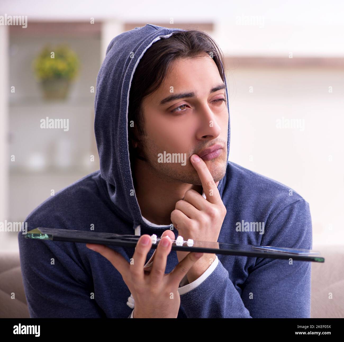 The young man having problems with narcotics at home Stock Photo - Alamy