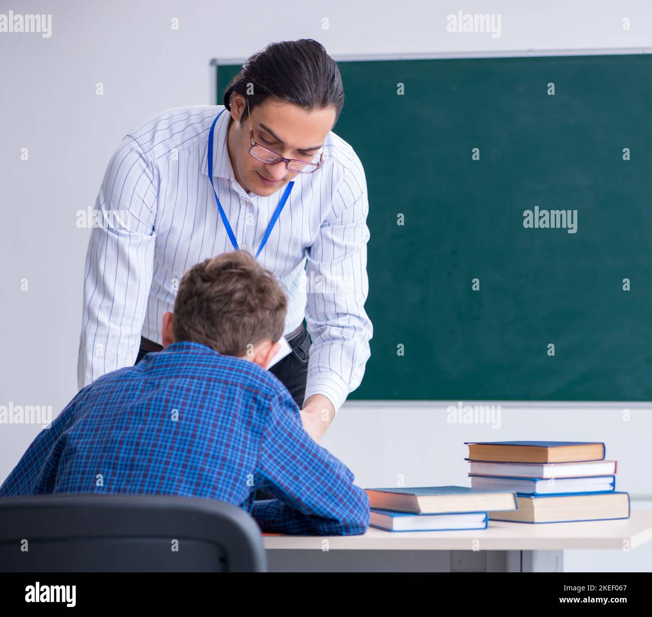 The young male teacher and boy in the classroom Stock Photo - Alamy