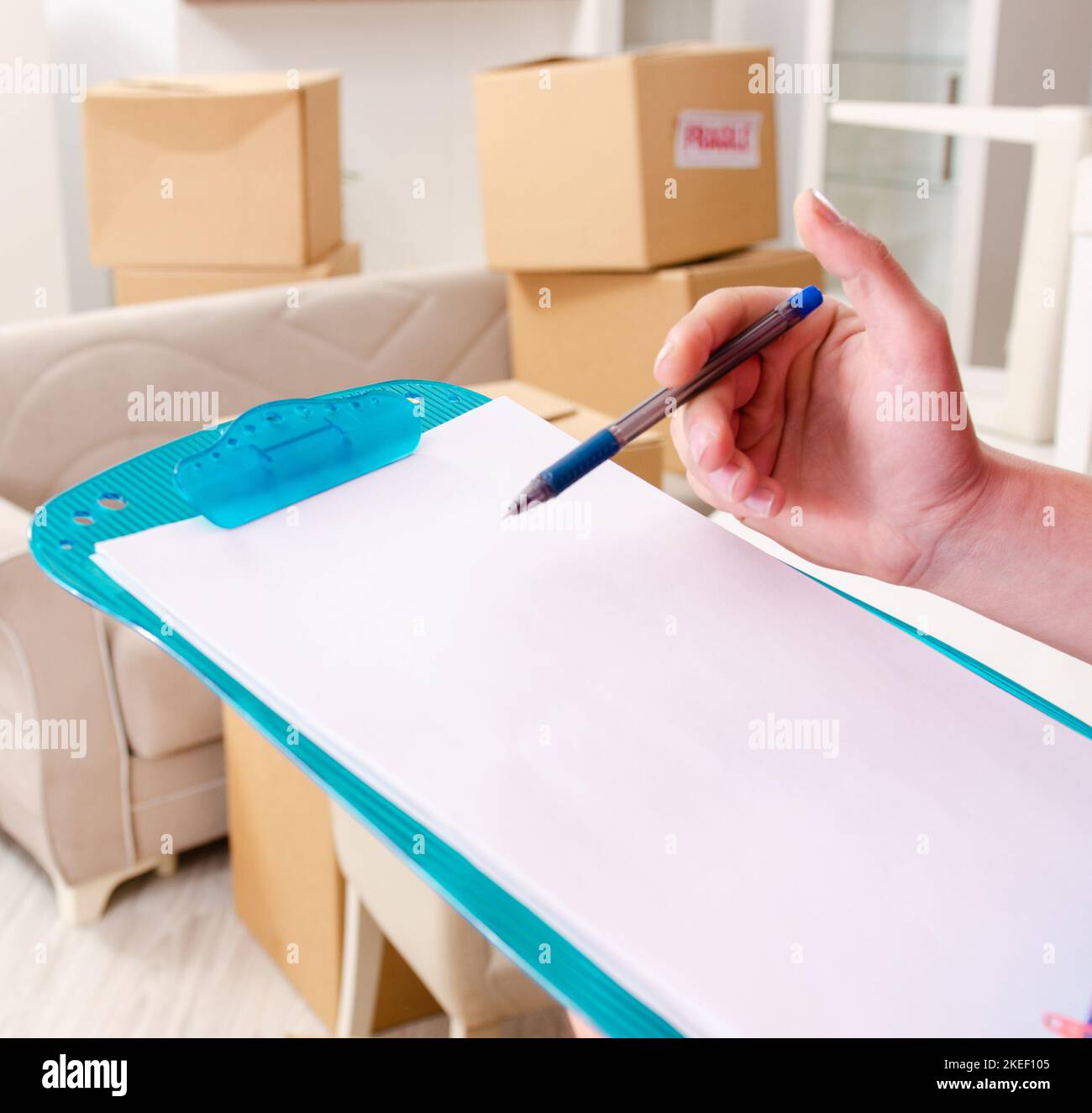 The young male contractor with boxes working indoors Stock Photo - Alamy