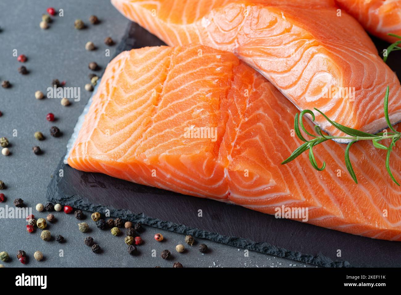 Salmon. Fresh raw salmon fish fillet with spices and rosemary on grey ...